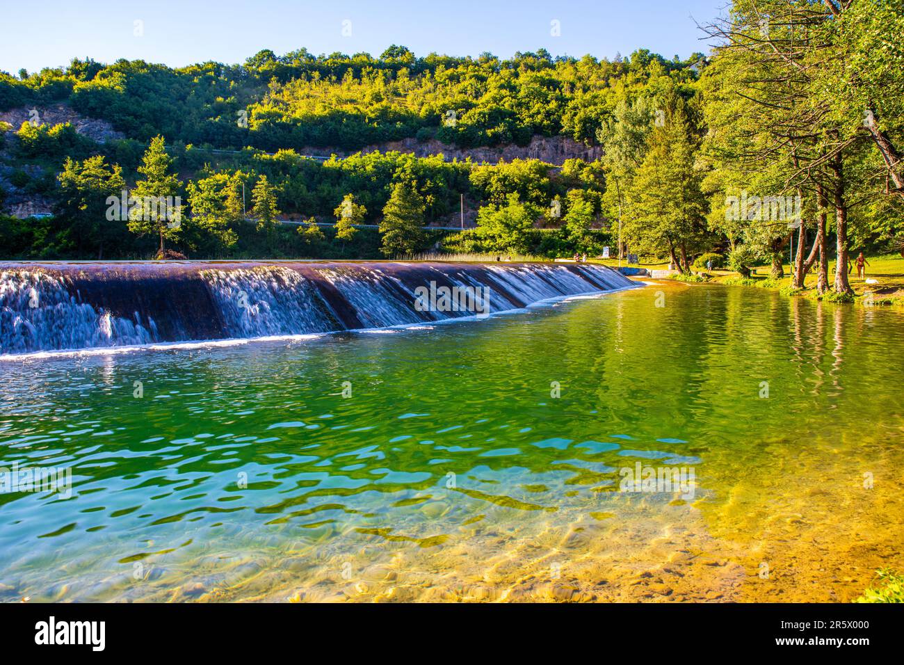 This vivid image features a stunning waterfall surrounded by lush ...