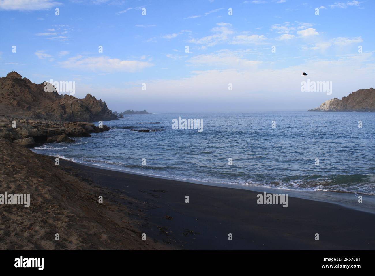 A scenic beach with a tranquil, unpopulated rocky shoreline. Peru Stock ...