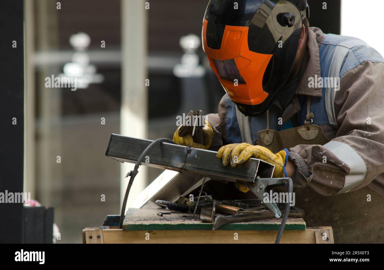 A blacksmith engaged in the process of metalworking, using tools to ...