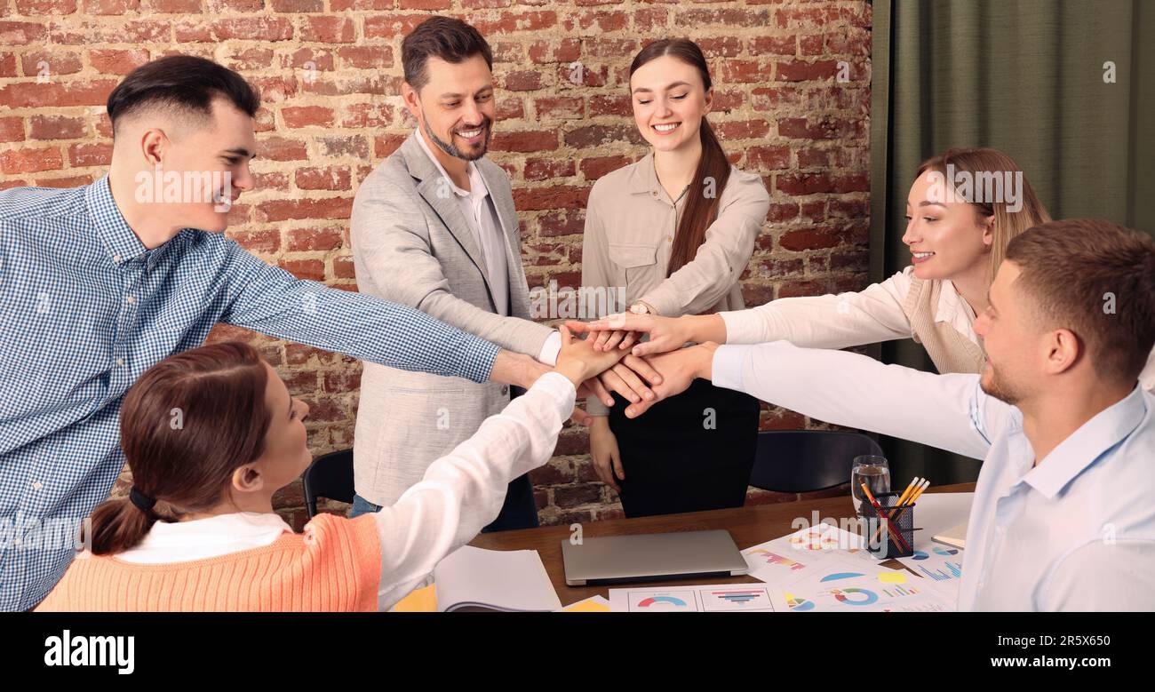 Business partners. Group of people holding hands together in office ...