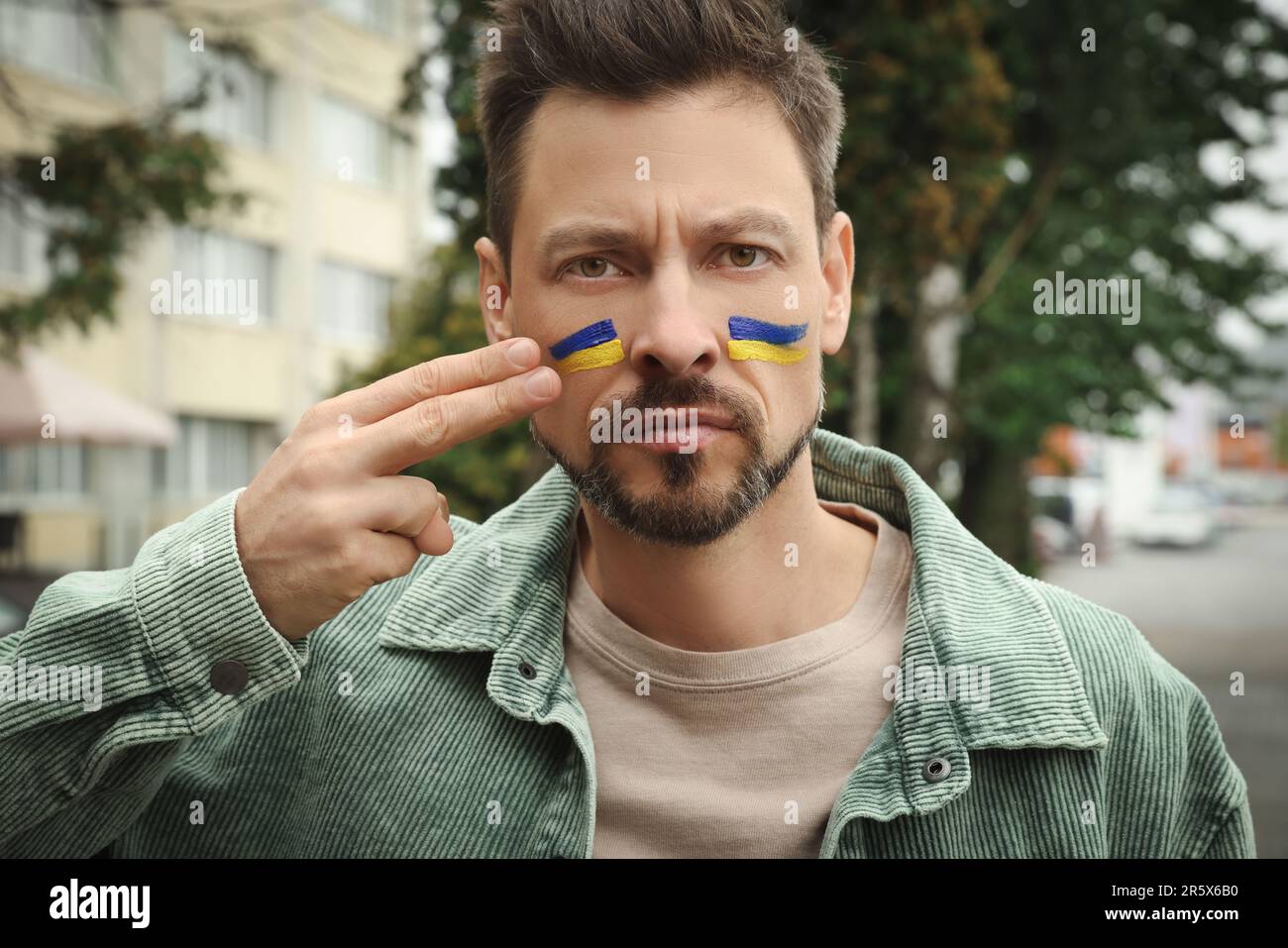 Angry man with drawings of Ukrainian flag on city street Stock Photo ...