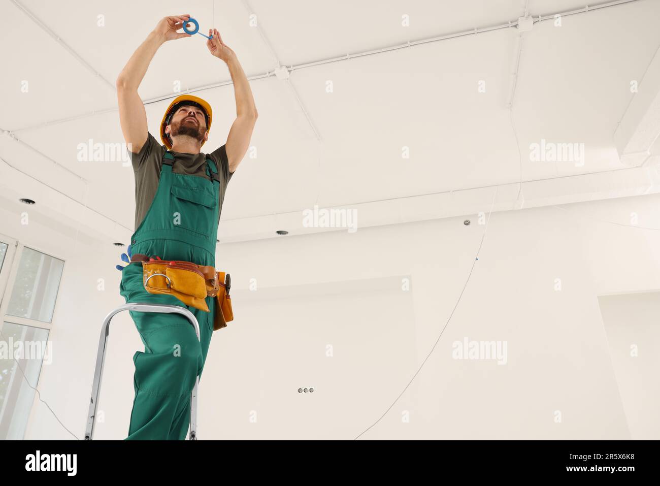 Electrician fixing wires with insulating tape indoors Stock Photo - Alamy