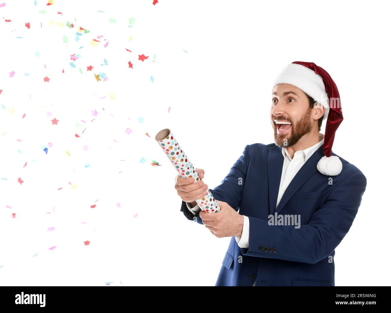 Emotional man blowing up party popper on white background Stock Photo ...