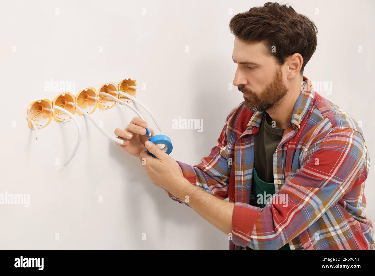 Electrician fixing wires with insulating tape indoors Stock Photo - Alamy