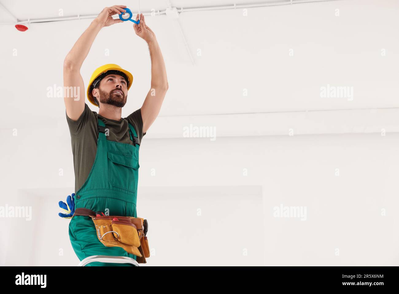 Electrician fixing wires with insulating tape indoors Stock Photo - Alamy