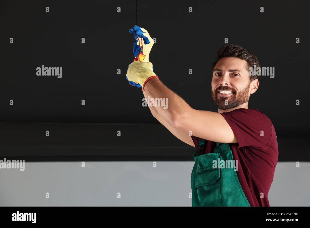 Electrician with pliers repairing ceiling wiring indoors Stock Photo ...
