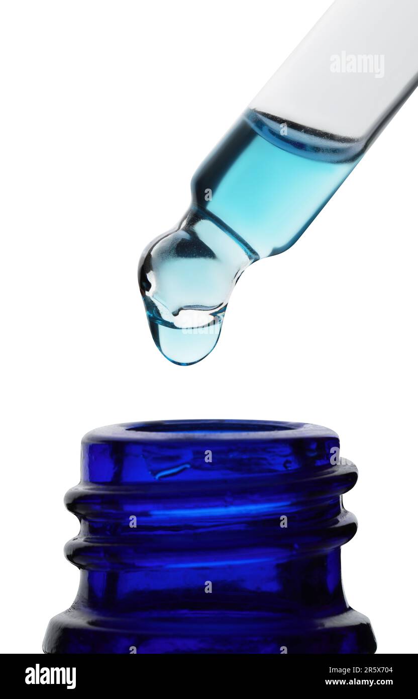 Dripping light blue facial serum from pipette into glass bottle on ...