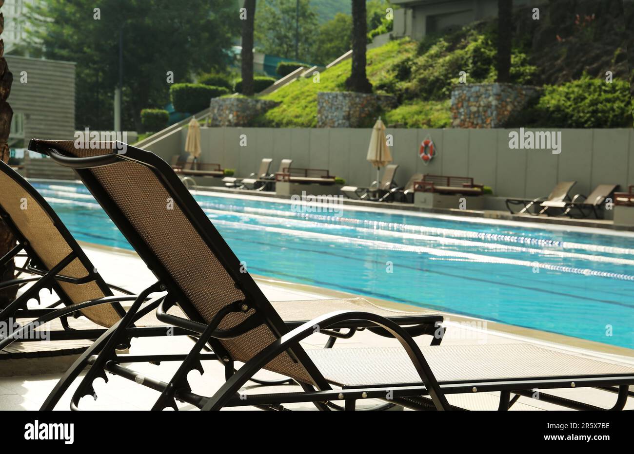 Sunbeds near swimming pool at luxury resort Stock Photo - Alamy