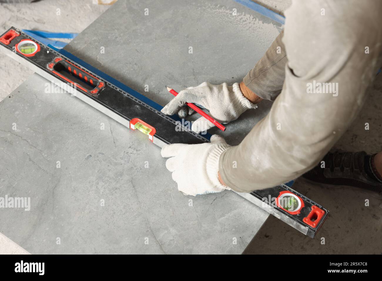 Worker measuring tiles for installation, closeup view Stock Photo - Alamy