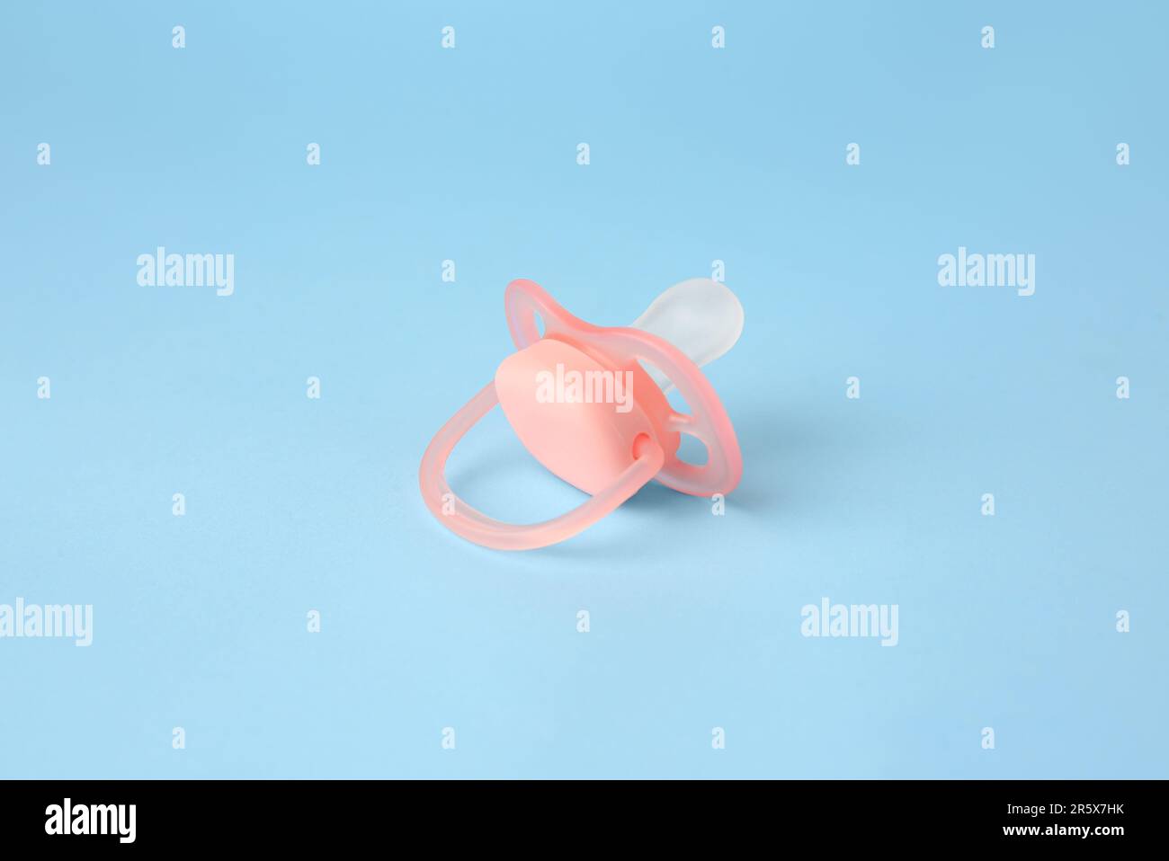 One new baby pacifier on light blue background Stock Photo - Alamy
