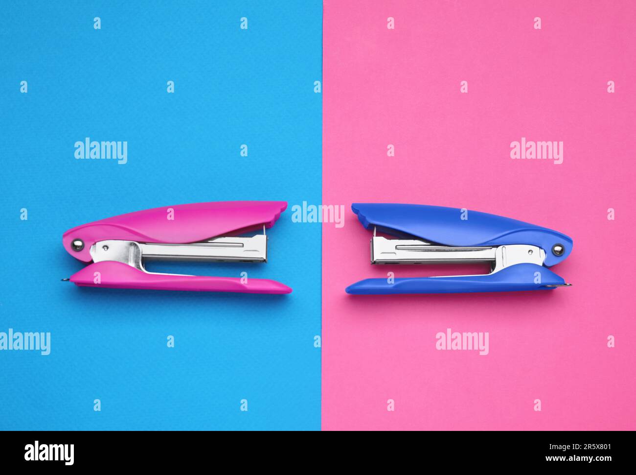 New bright staplers on color background, flat lay. School stationery ...