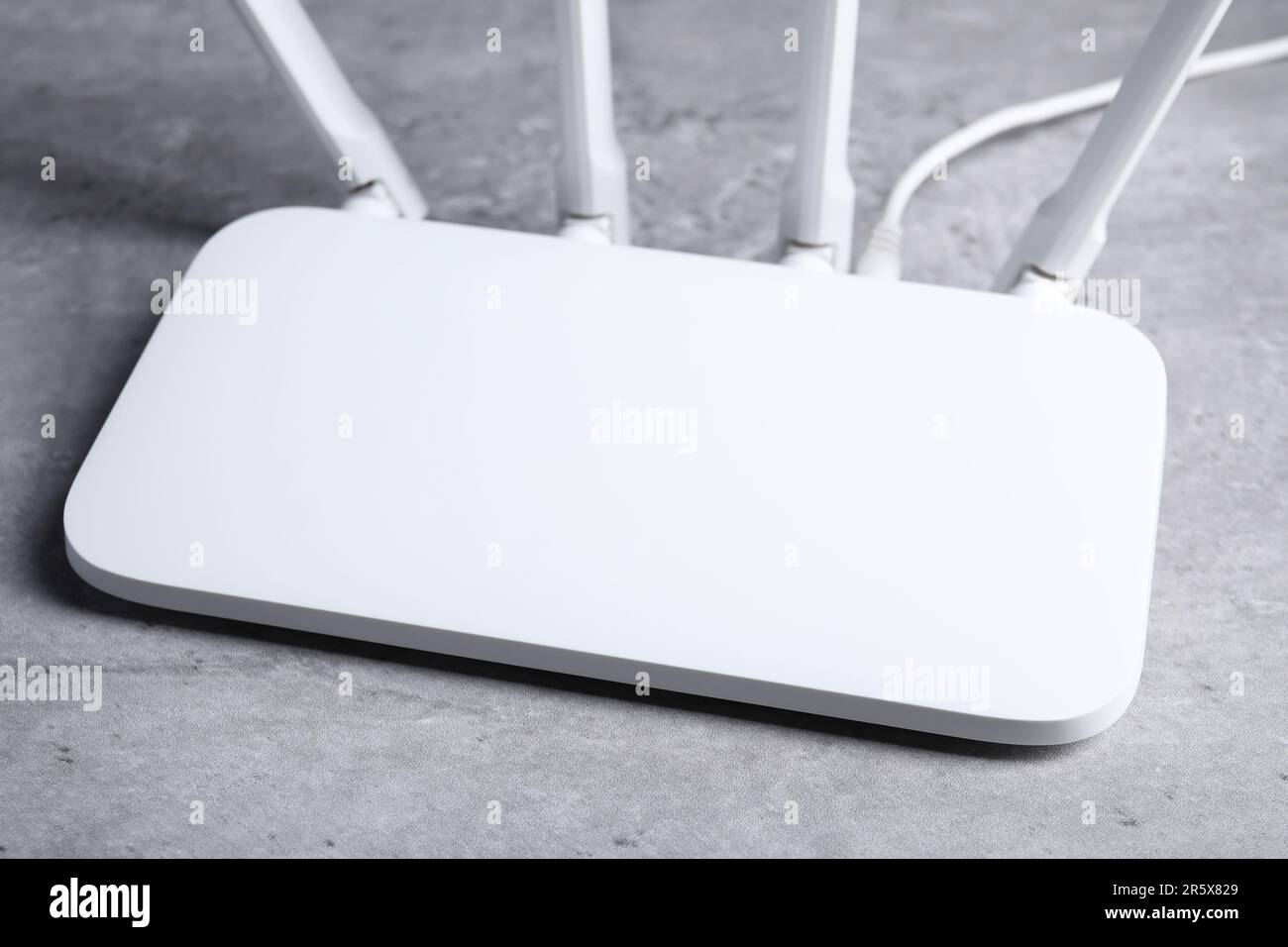 New white Wi-Fi router on grey textured table, closeup Stock Photo - Alamy