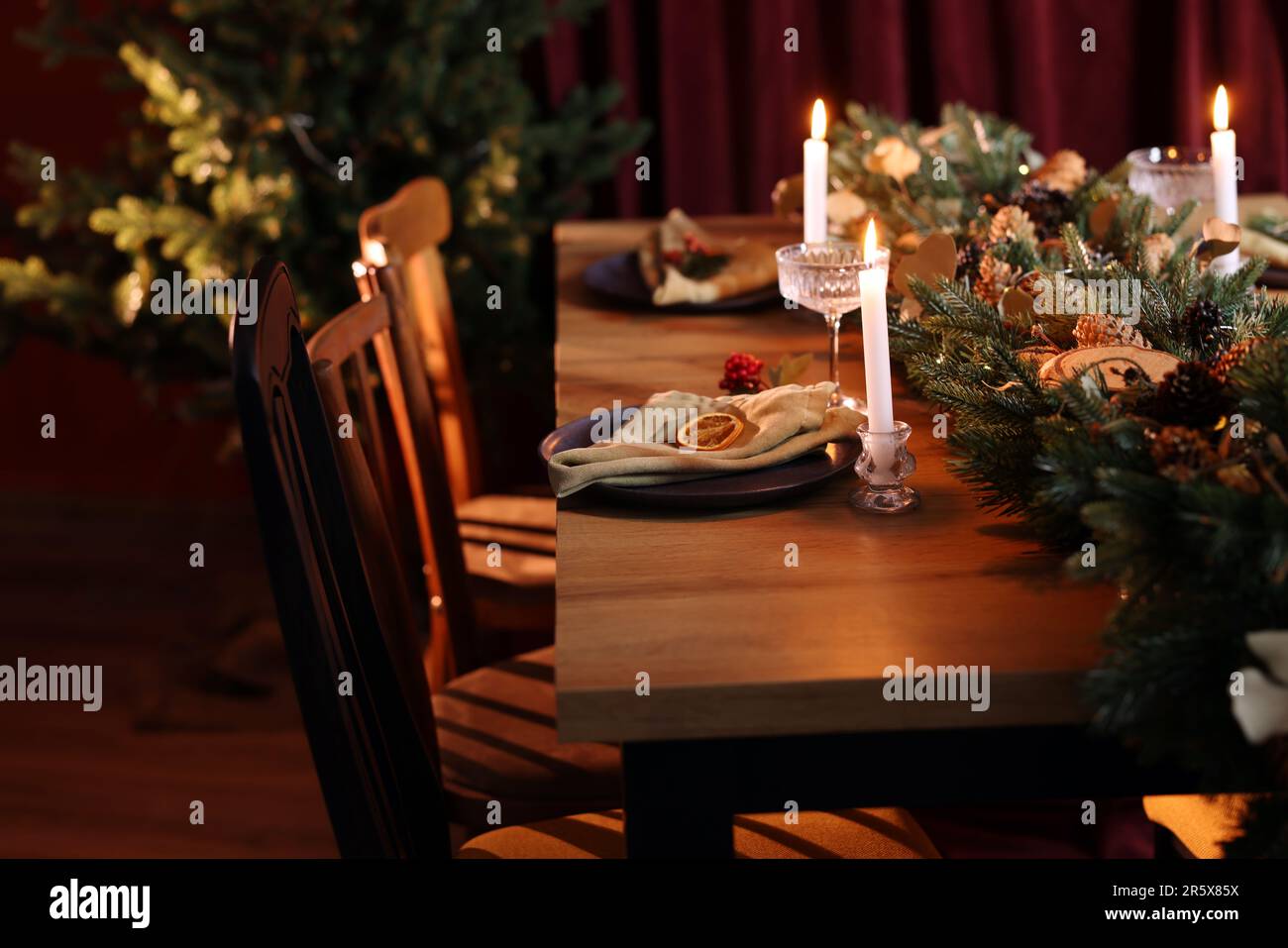 Dining table with burning candles and Christmas decor in stylish room ...