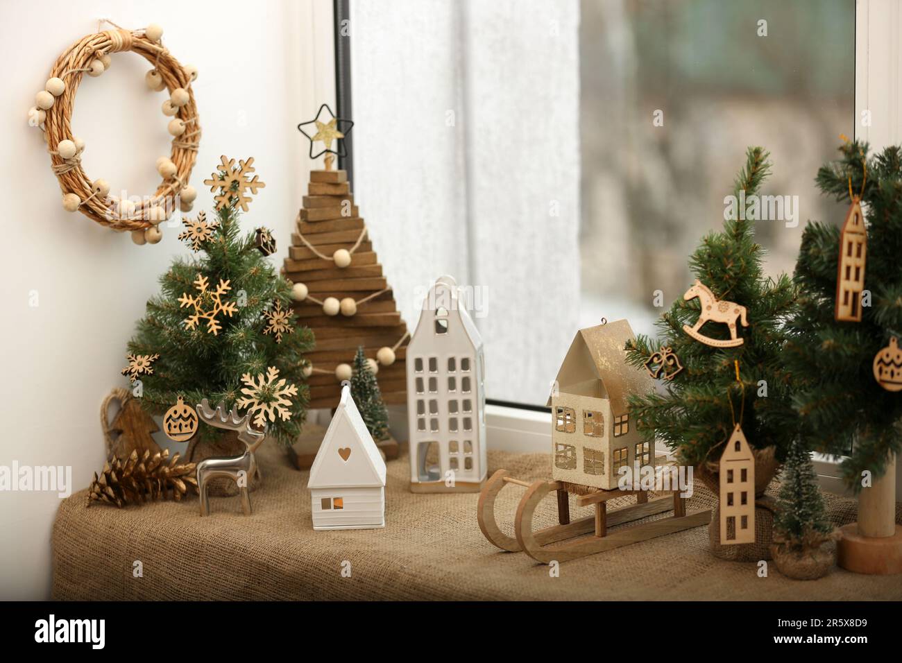 Beautiful window sill decorated for Christmas with small houses and fir ...