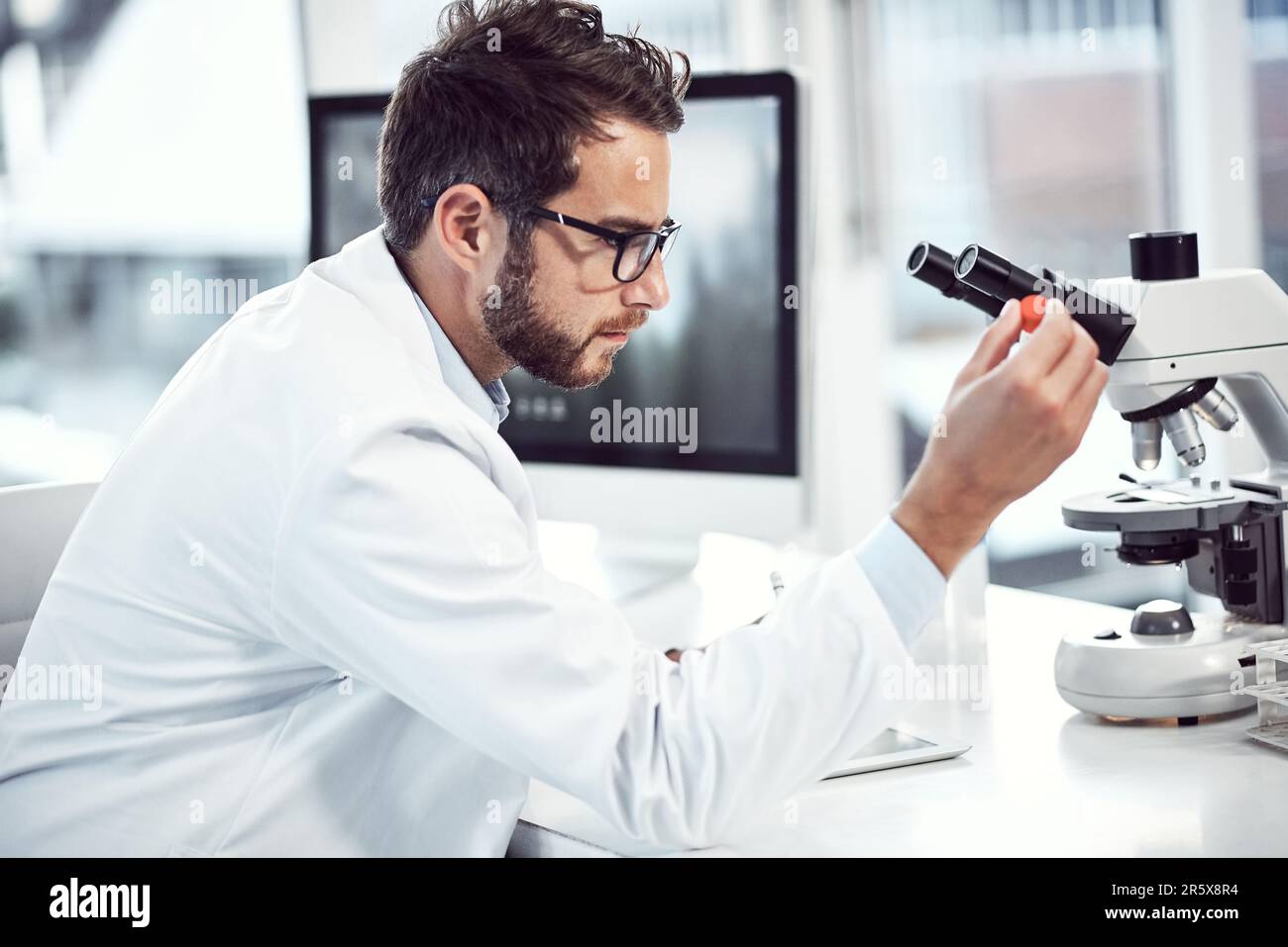 This took a lot of time. a focused young male scientist examining a ...