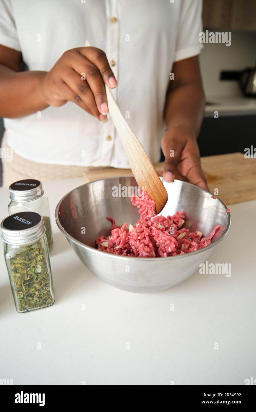 Close up of cuban woman hands mixing raw minced beef and garlic Stock ...