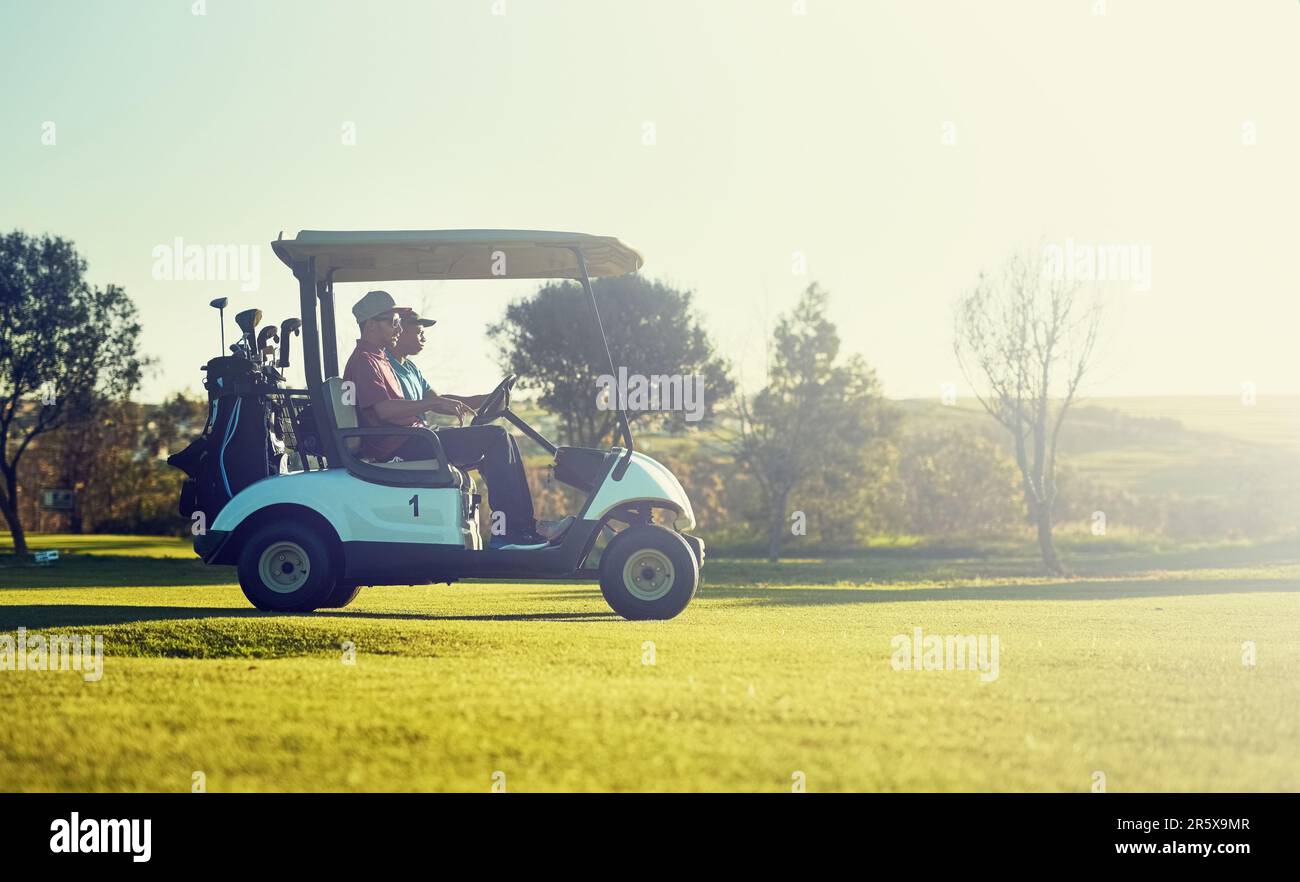 Gone clubbin. two golfers riding in a cart on a golf course Stock Photo ...