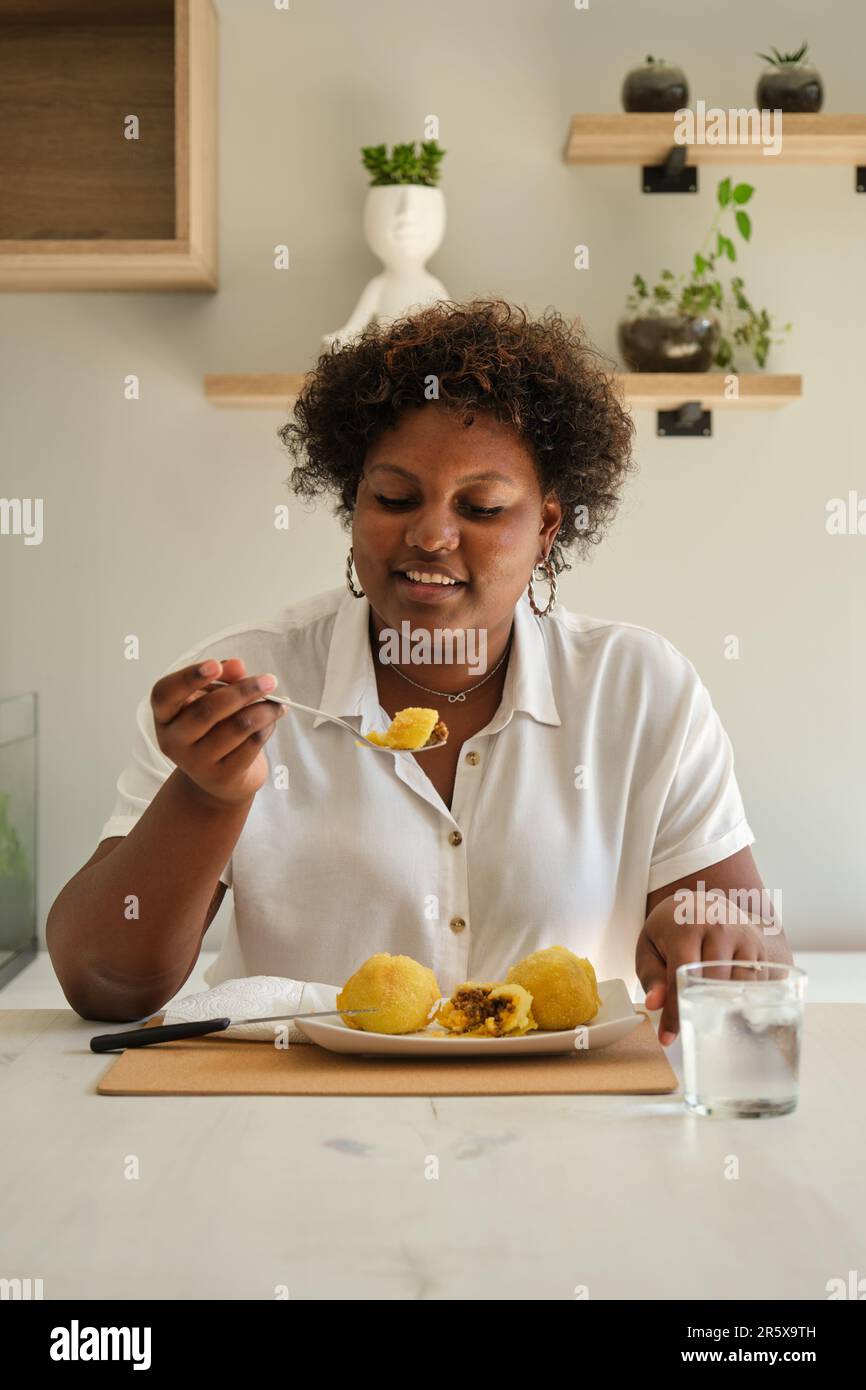 Young cuban woman eating homemade cuban style stuffed potatoes Stock ...