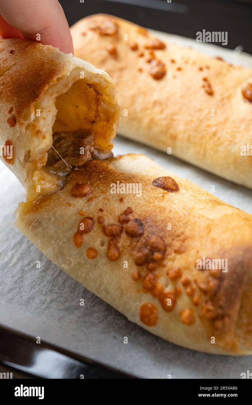 angle view hand with fresh baked cheese beef roll Stock Photo - Alamy
