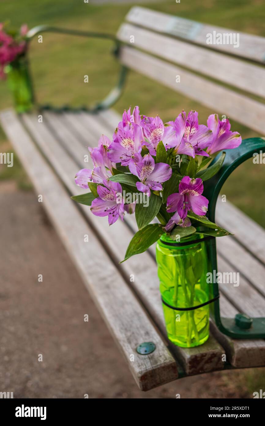 Beautiful small flower bouquet on the bench. Wooden Bench in a garden ...