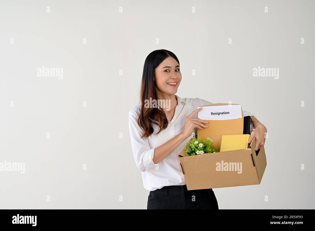 An excited and cheerful young Asian female employee feels happy to quit ...