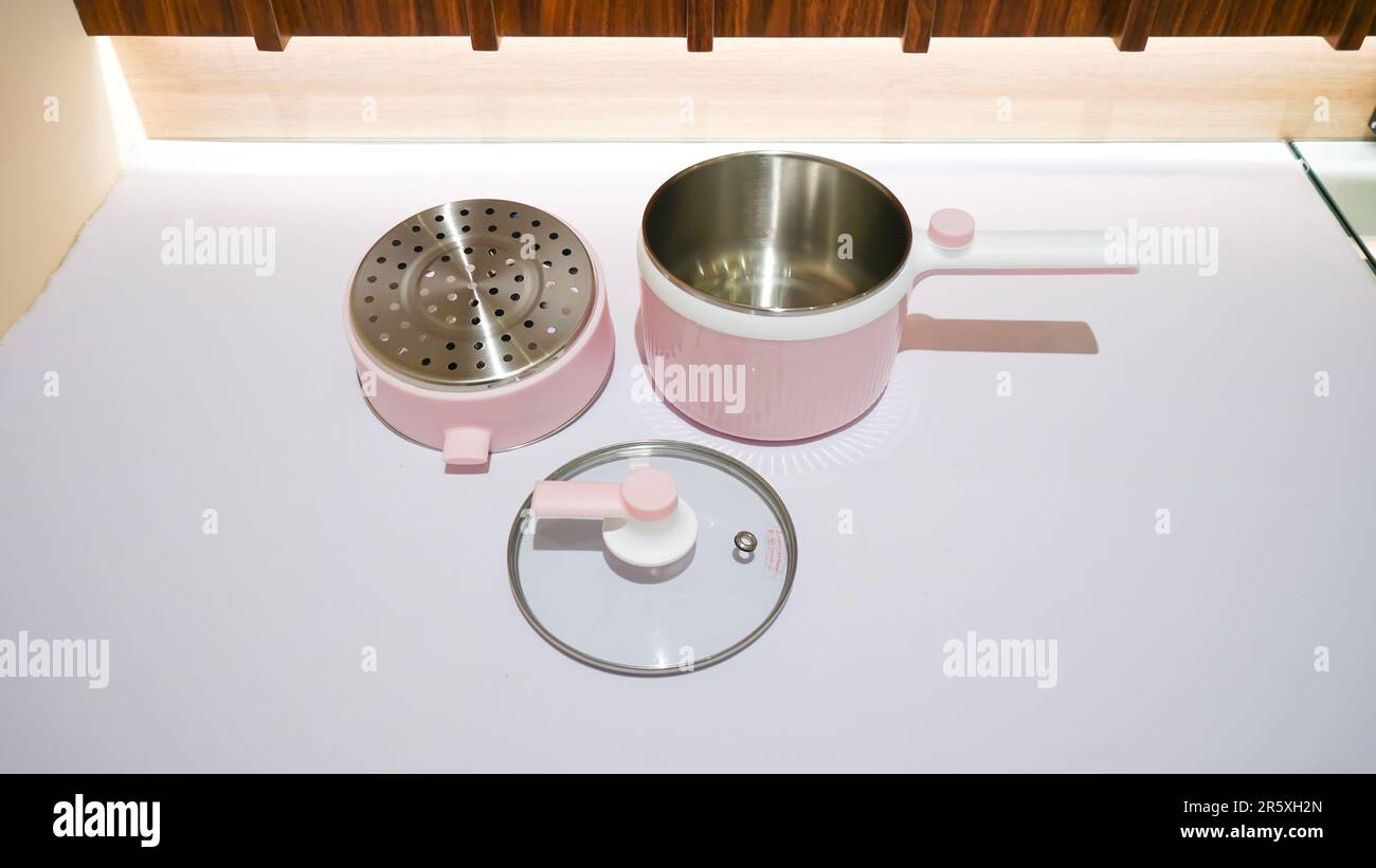 An elegant pink electric steamer is a kitchen appliance that uses steam ...