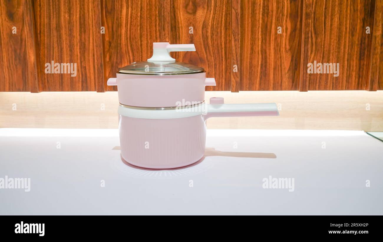 An elegant pink electric steamer is a kitchen appliance that uses steam ...