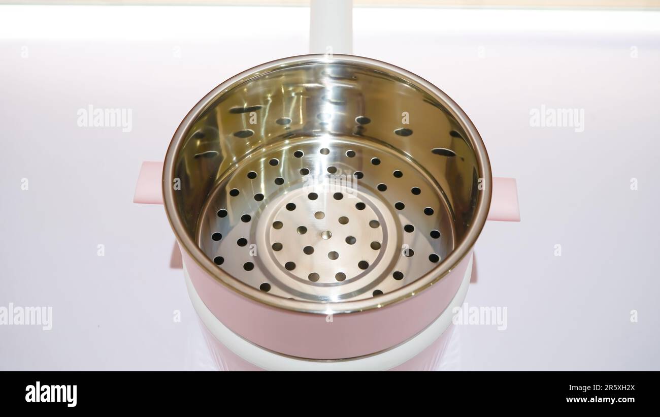 An elegant pink electric steamer is a kitchen appliance that uses steam ...