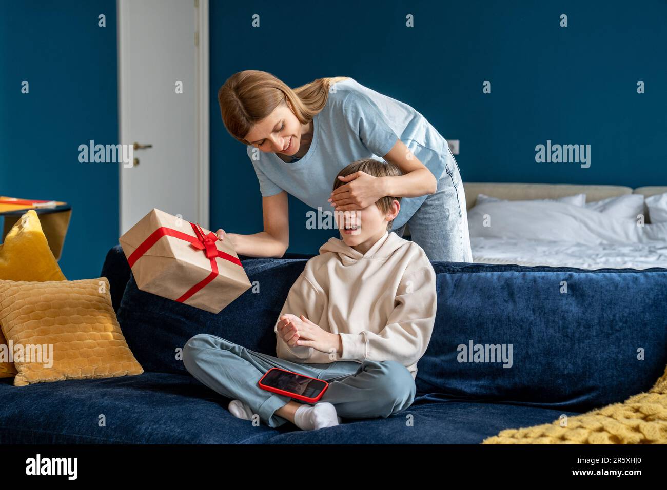 Young happy loving mother closing eyes of child son congratulating ...