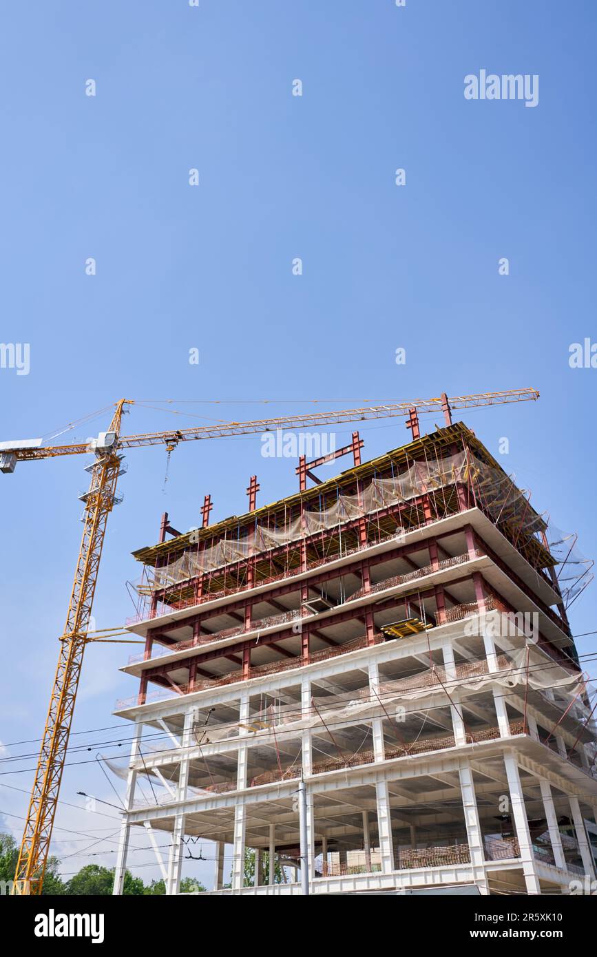 Hydraulic luffing jib tower cranes and workers being poured concrete ...