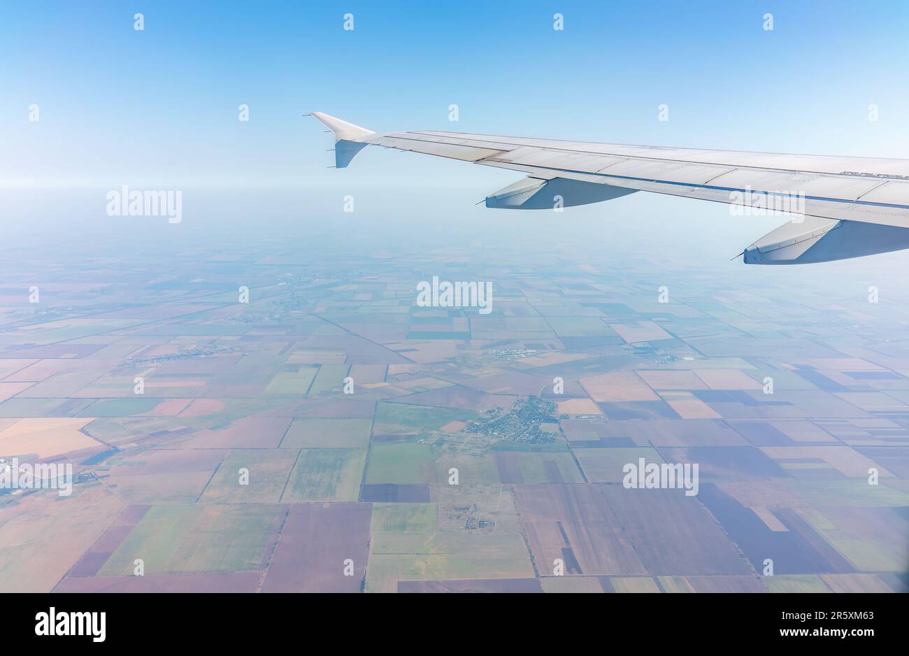 Aerial view from airplane window above green ground. View from the ...