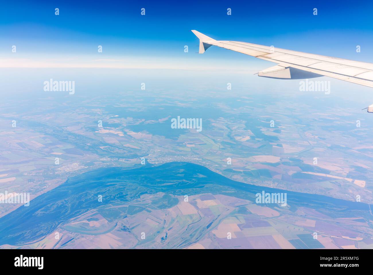 Aerial view from airplane window above green ground. View from the ...