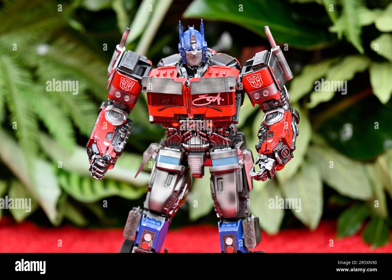 An Optimus Prime toy posed on the red carpet at the premiere of ...