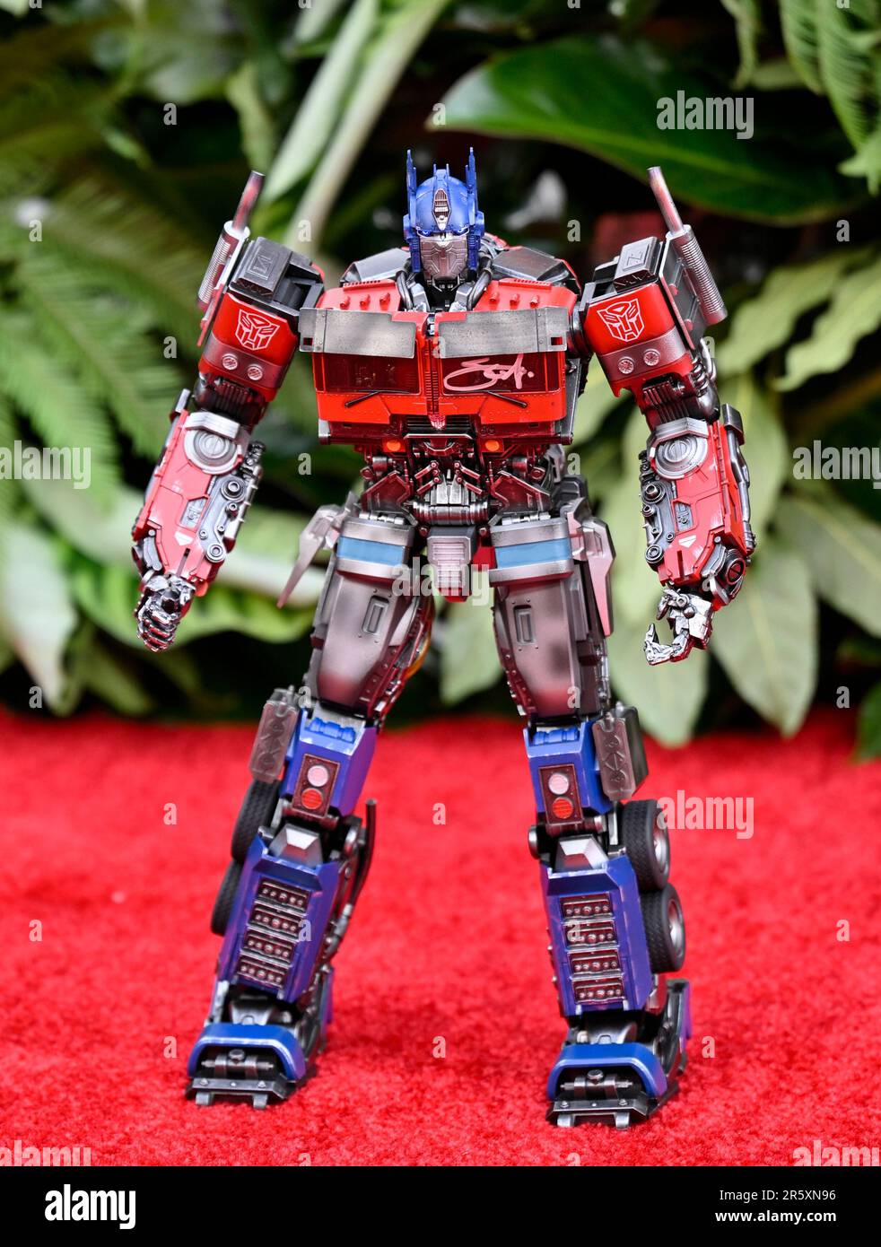 An Optimus Prime toy posed on the red carpet at the premiere of ...