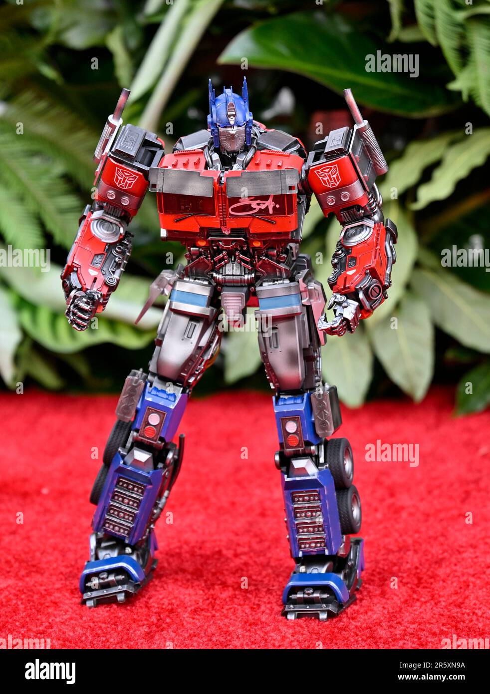 An Optimus Prime toy posed on the red carpet at the premiere of ...