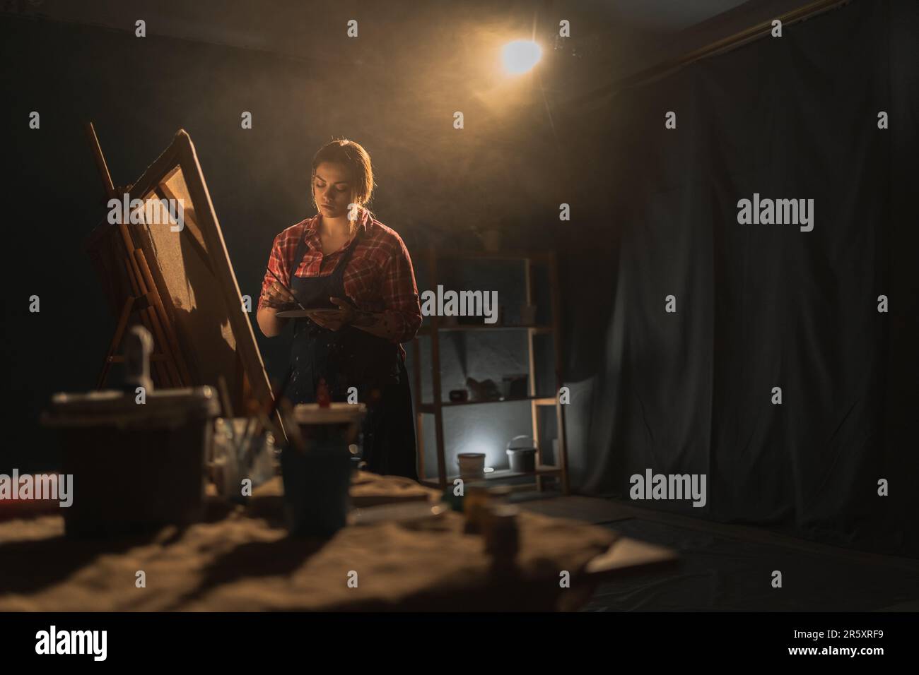 Young female artist works on abstract painting, creates modern ...