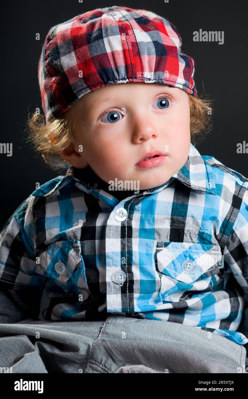 Casual cool young child with cap in front of grey background Stock ...