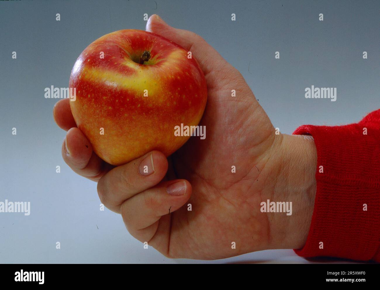 Hand with apple Stock Photo - Alamy