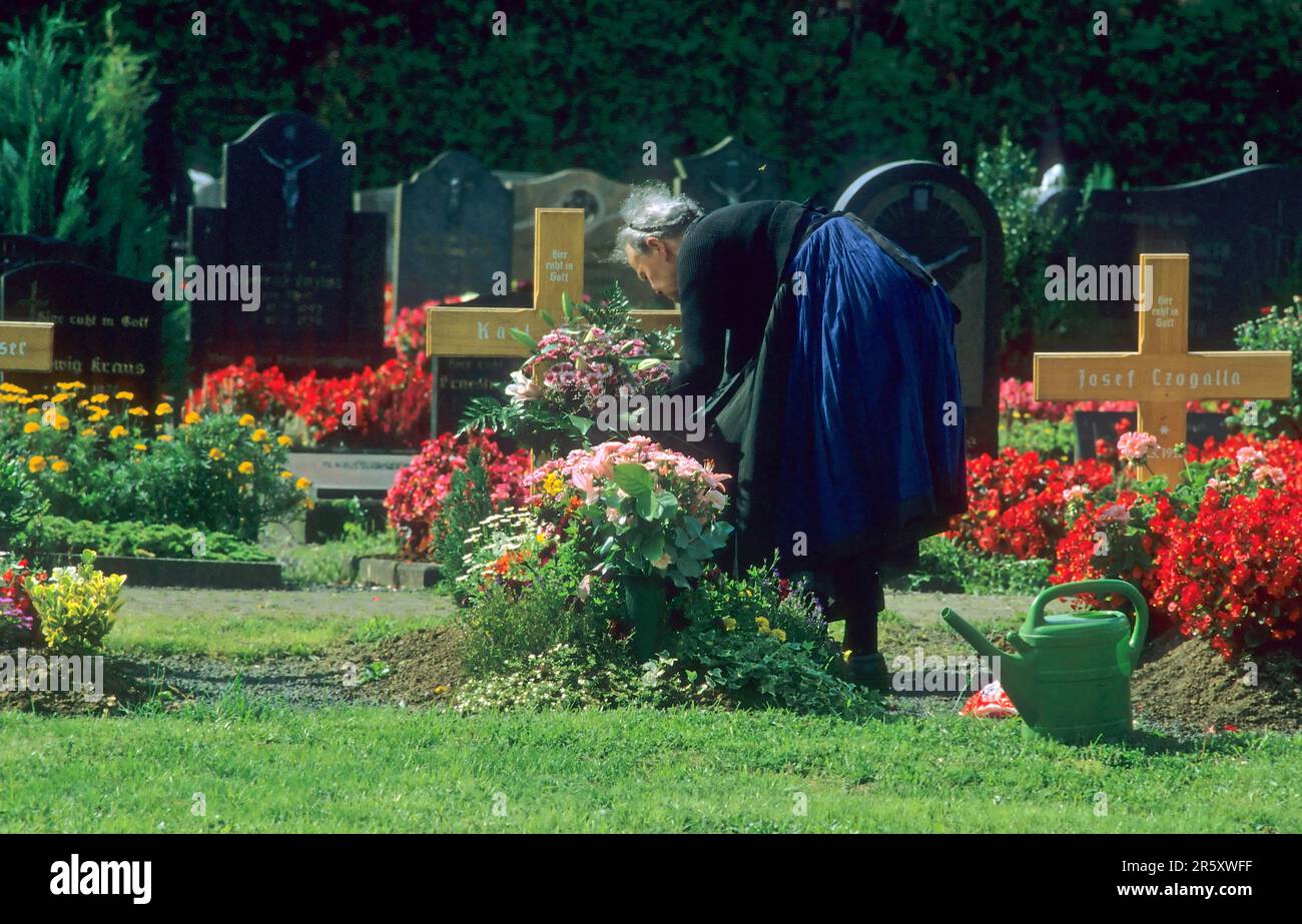 Old woman at the grave in the cemetery Stock Photo - Alamy