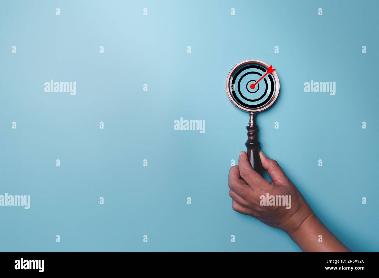 Hand holding target board inside vintage magnifying glass for focus ...