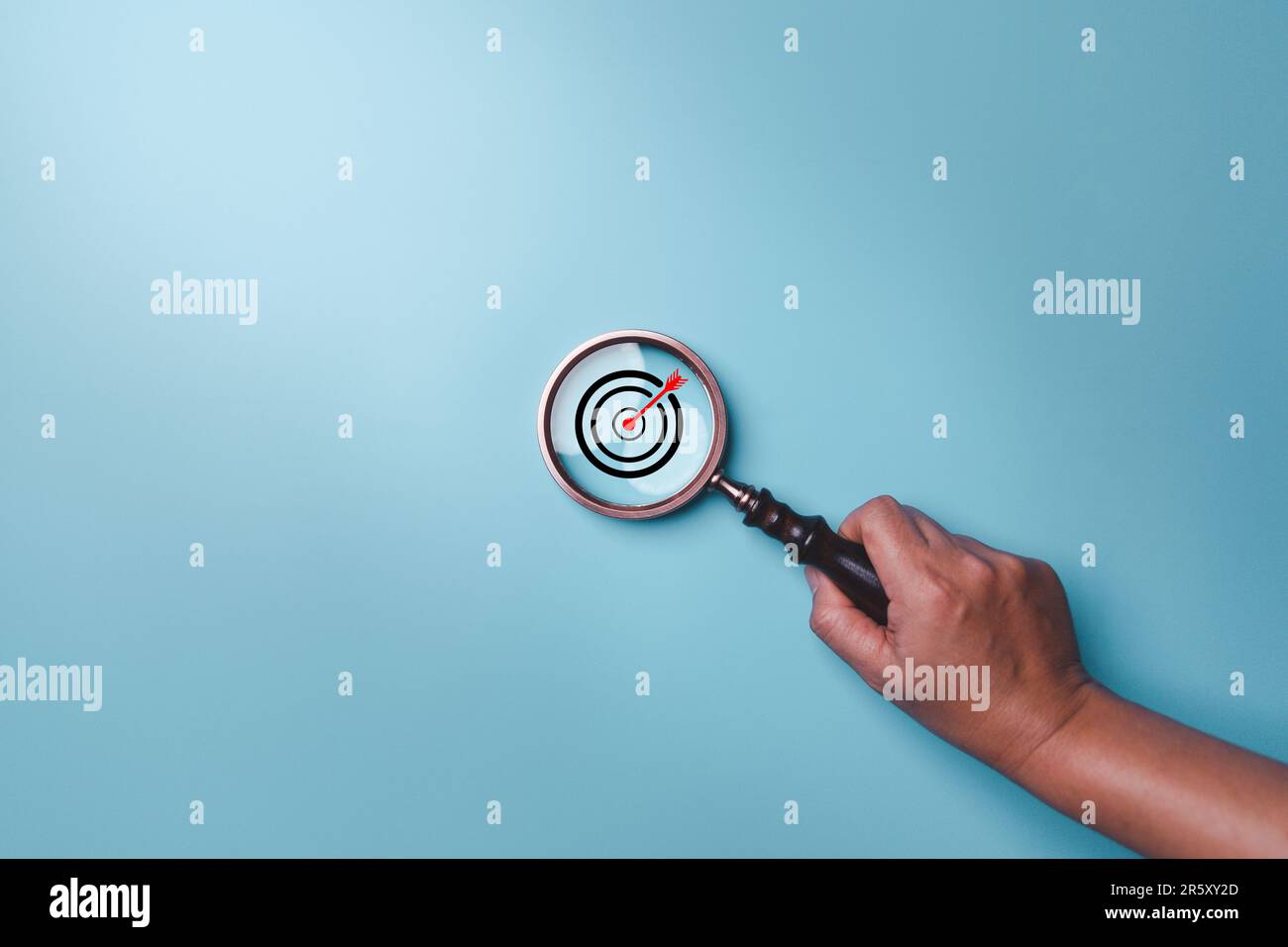 Hand holding target board inside vintage magnifying glass for focus ...