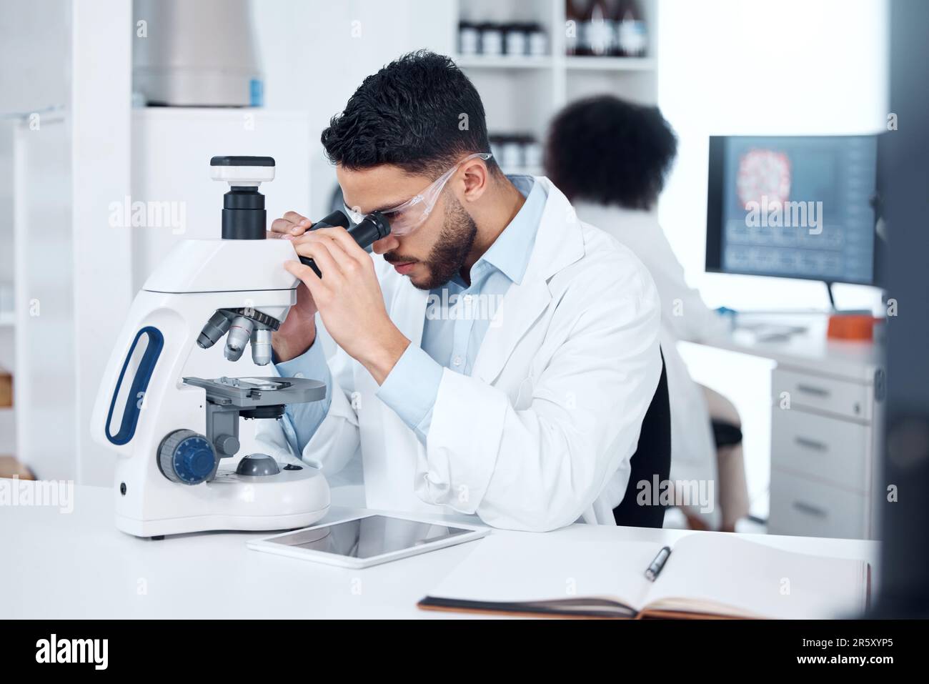 Science, microscope and male scientist analyzing with biotechnology in ...
