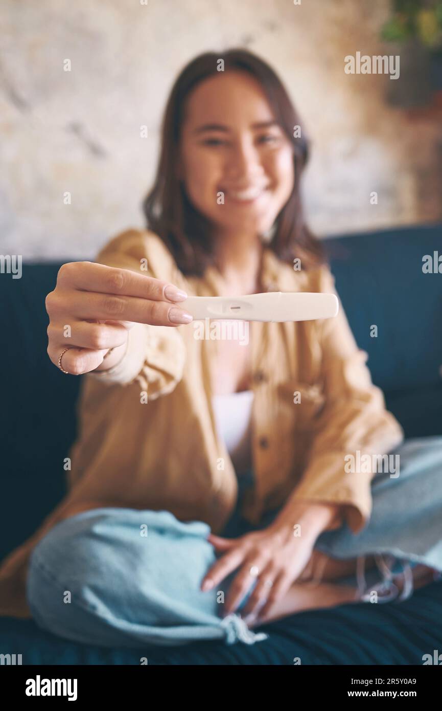 New life loading...a young woman taking a pregnancy test on the sofa at ...