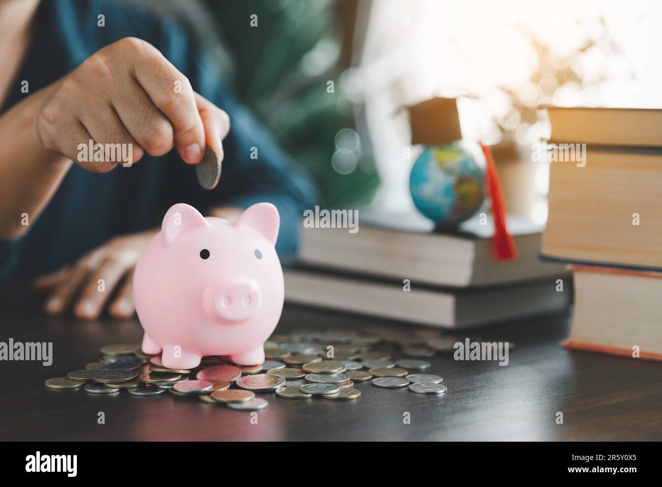 Hand putting coins in a piggy bank. Concept of saving money for a ...