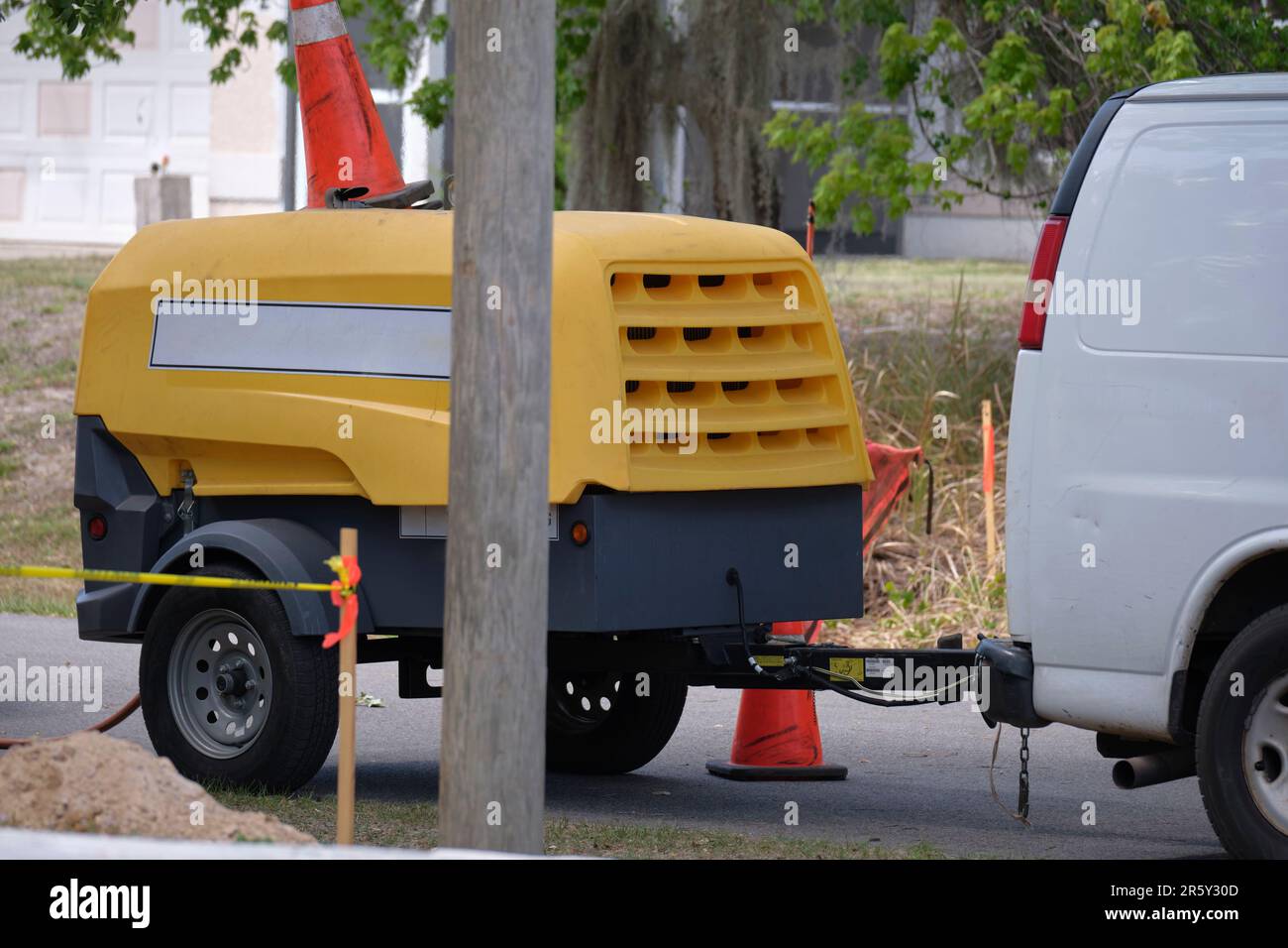 Utility van with yellow compressor trailer with jackhammer machine on ...