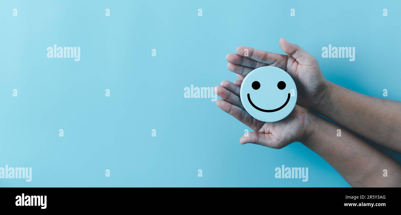 Woman hand holding happy face smile face icon on round blue object ...