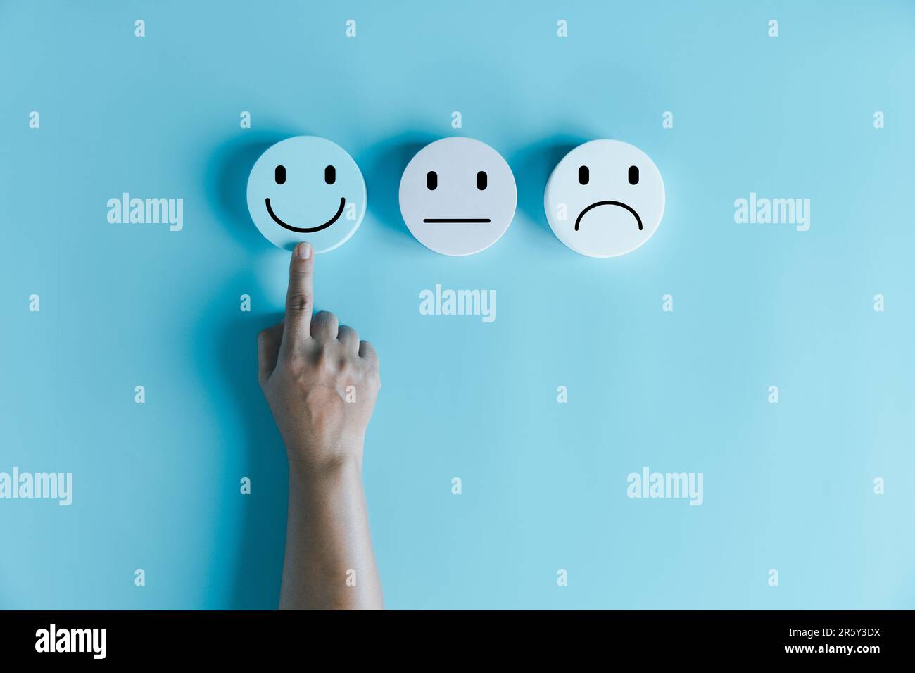 Woman hand touching happy face smile face icon on round blue object ...