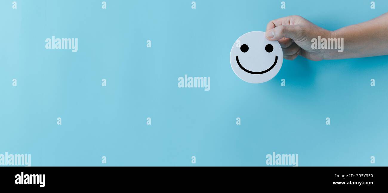 Woman hand holding happy face smile face icon on round blue object ...