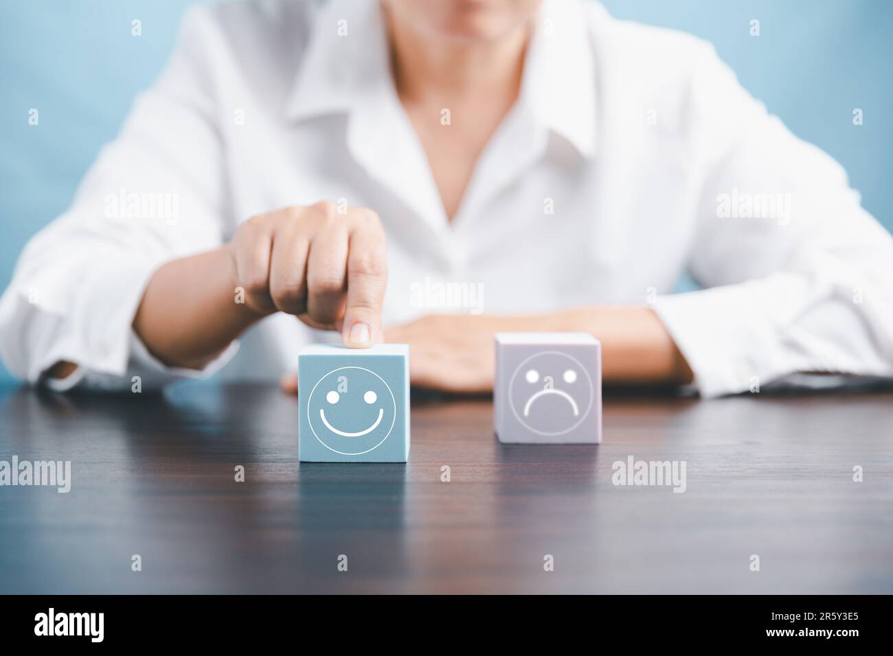 Woman hand holding happy face smile face icon on cube blue object ...