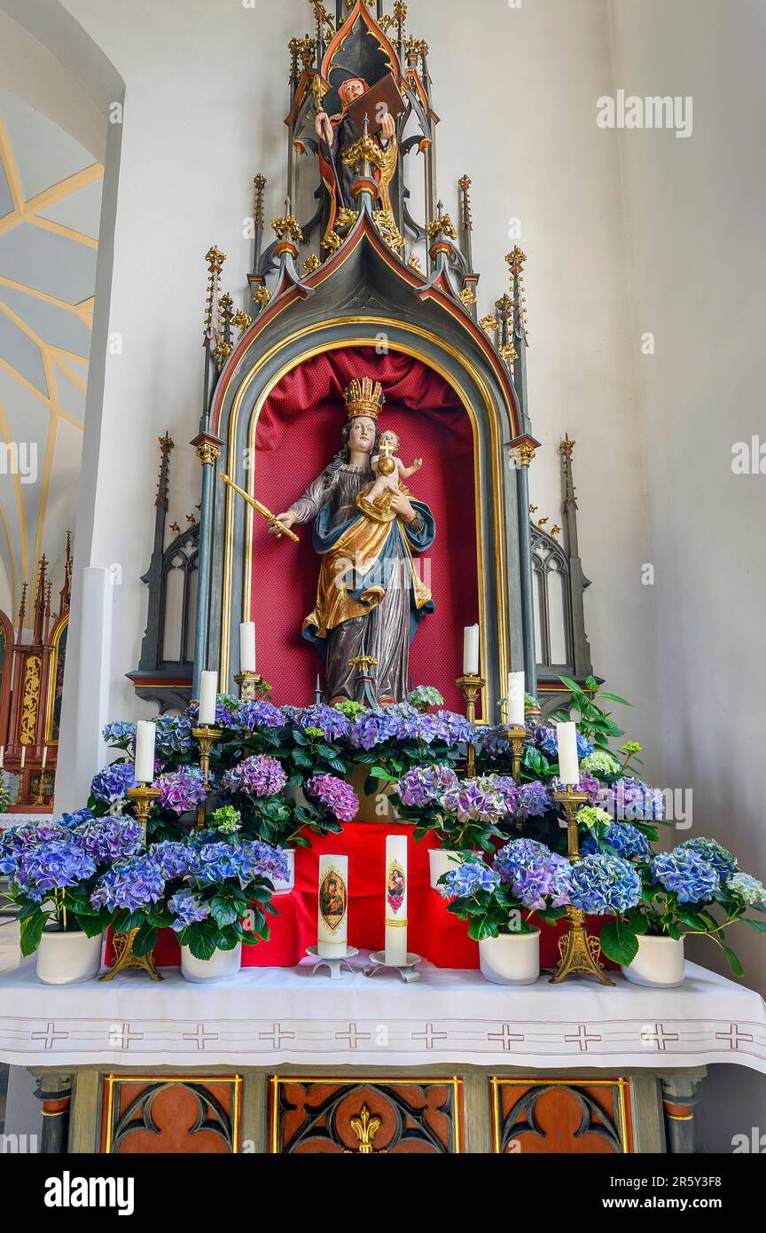 Side altar and figure of Mary with crown and baby Jesus in the church ...